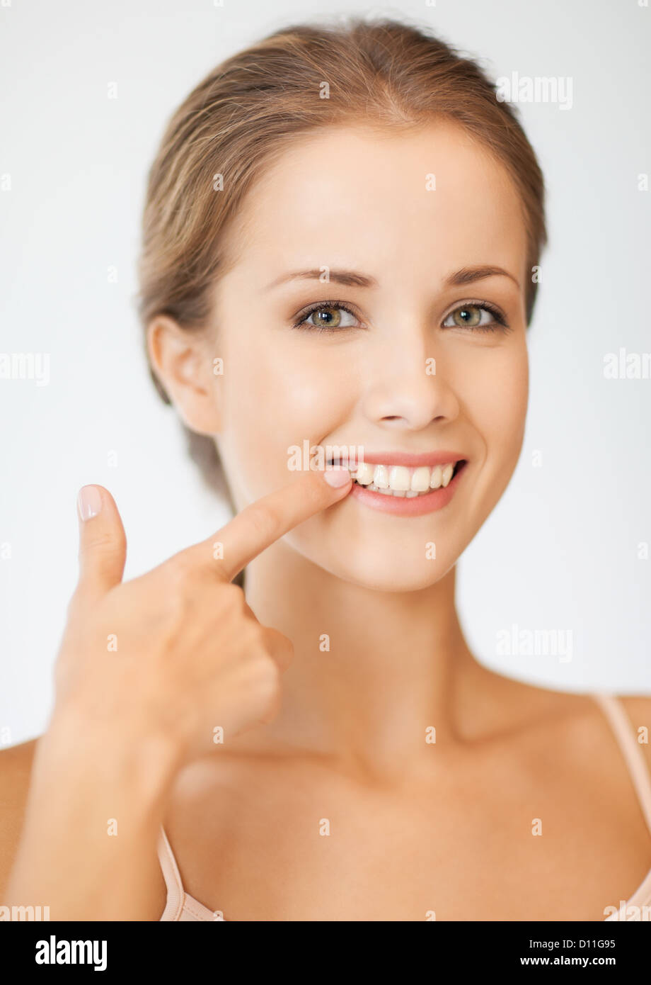 beautiful woman pointing to teeth Stock Photo - Alamy