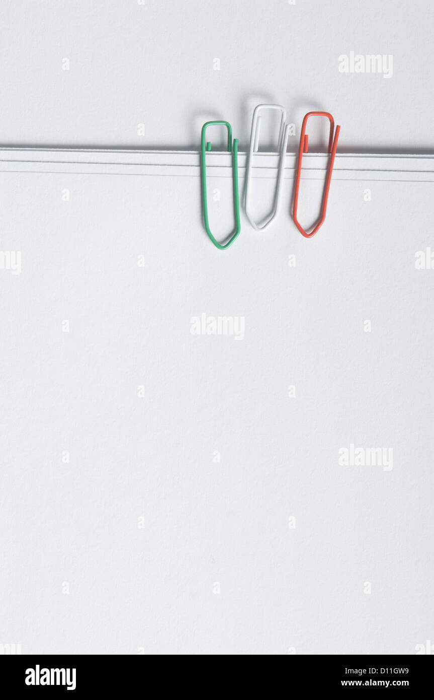 Three paper clips in Italian national colours against white background ...