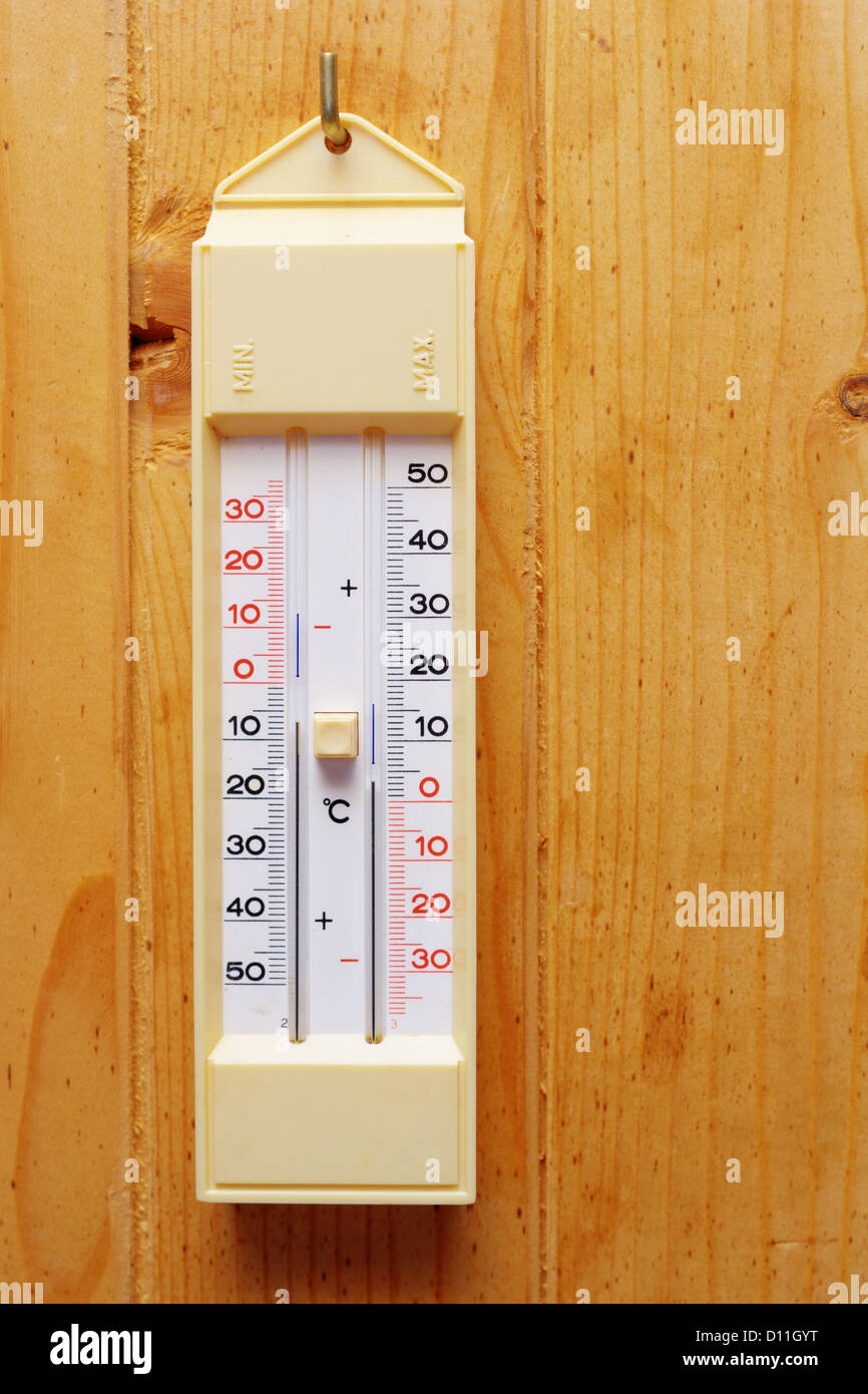 thermometer hanging on a nail over wooden wall at the exterior of a ...