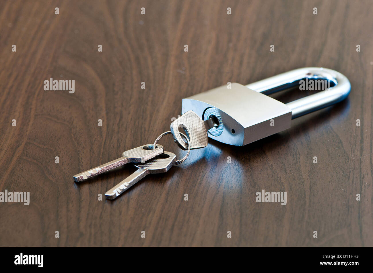 closed padlock and key`s on the brown table Stock Photo - Alamy
