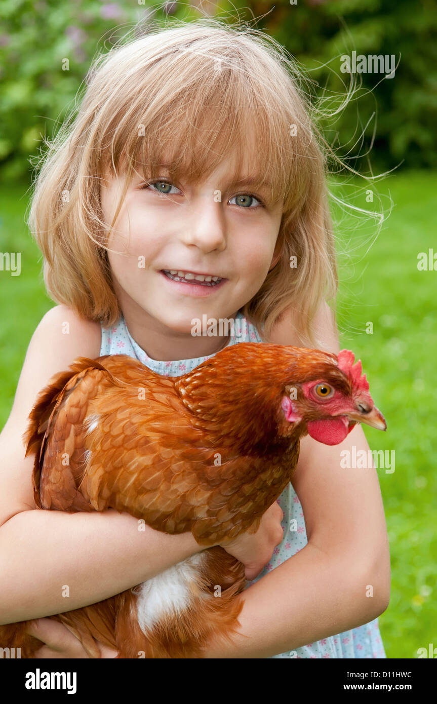 Germany, Brandenburg, Girl holding hen, smiling, portrait Stock Photo ...