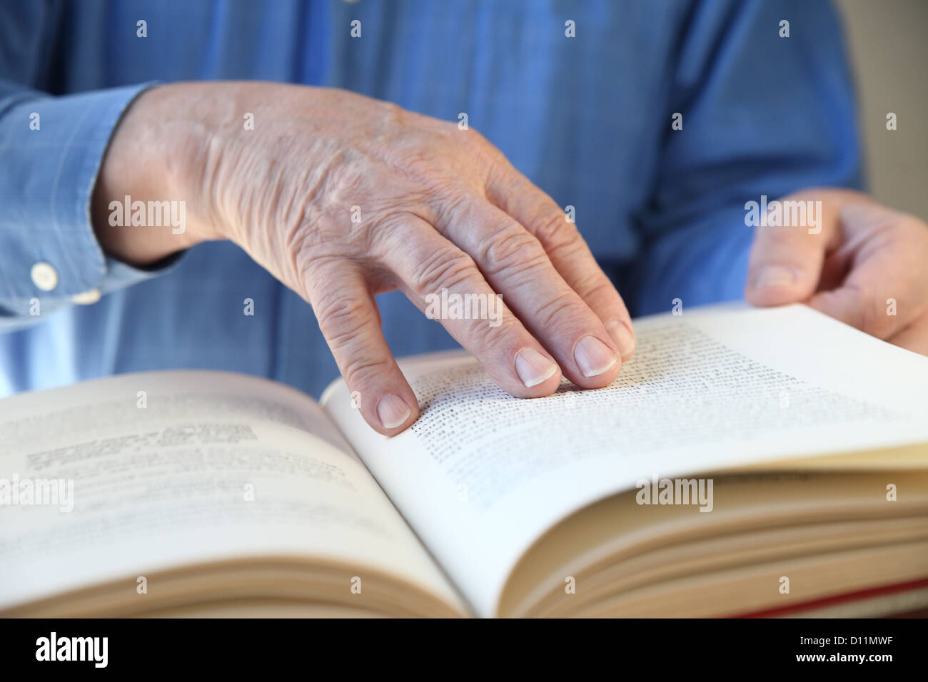 a senior man's hands on a book Stock Photo - Alamy