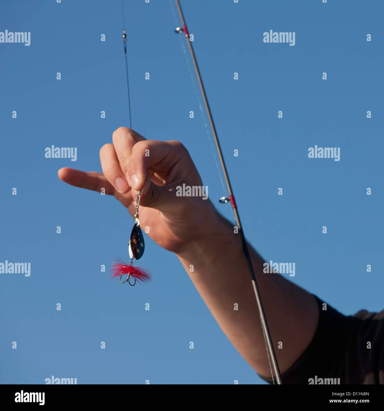 Sweden, Young man holding fishing rod with bait and hook Stock Photo ...