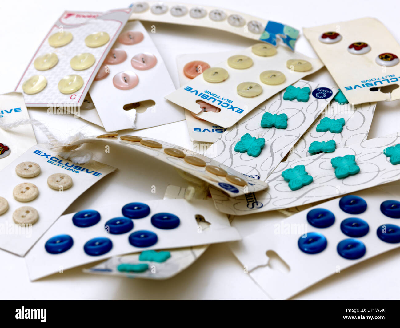 A Pile Of Buttons On Cardboard Stock Photo - Alamy