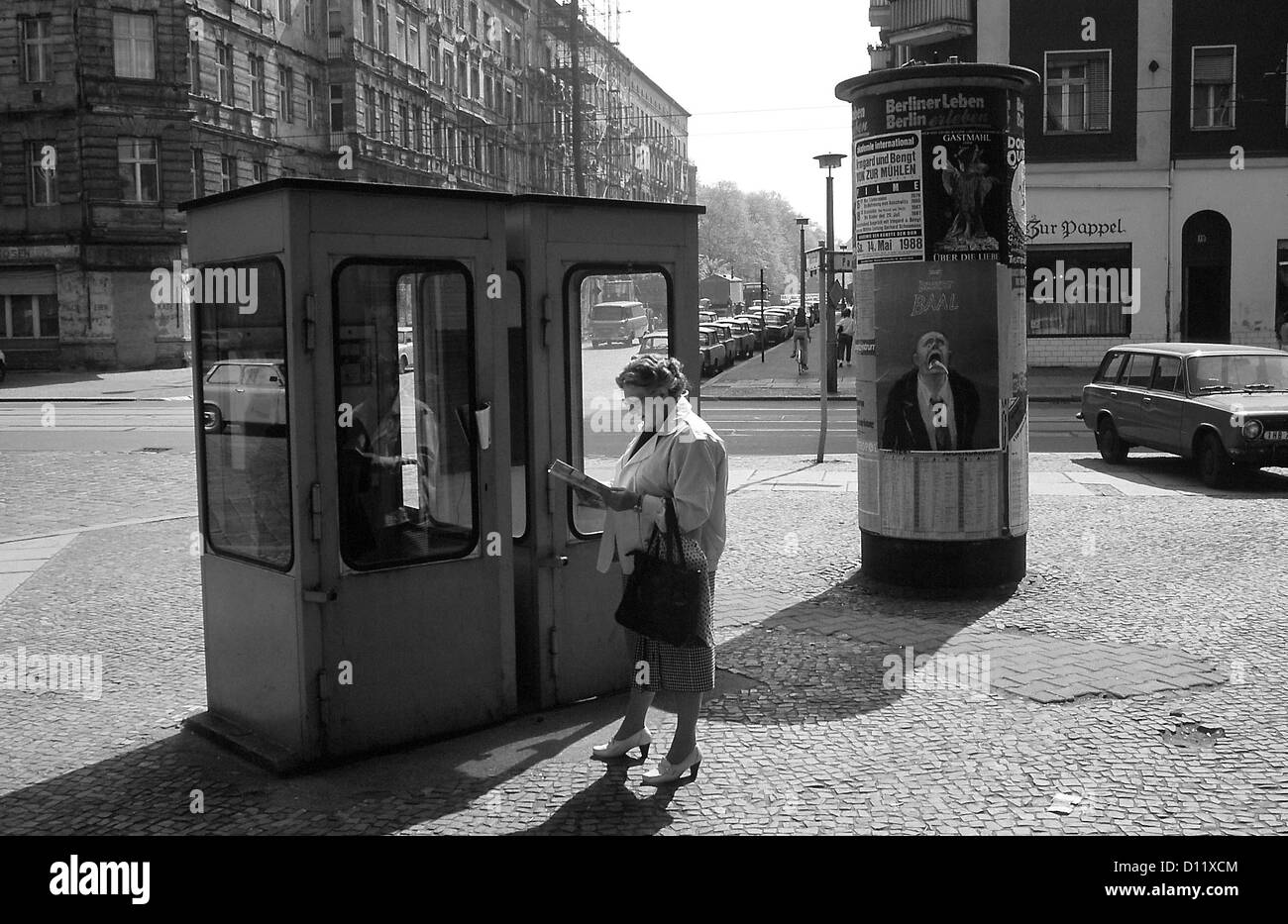 Berlin, GDR, a woman stands in front of phone booths in Prenzlauer Berg ...