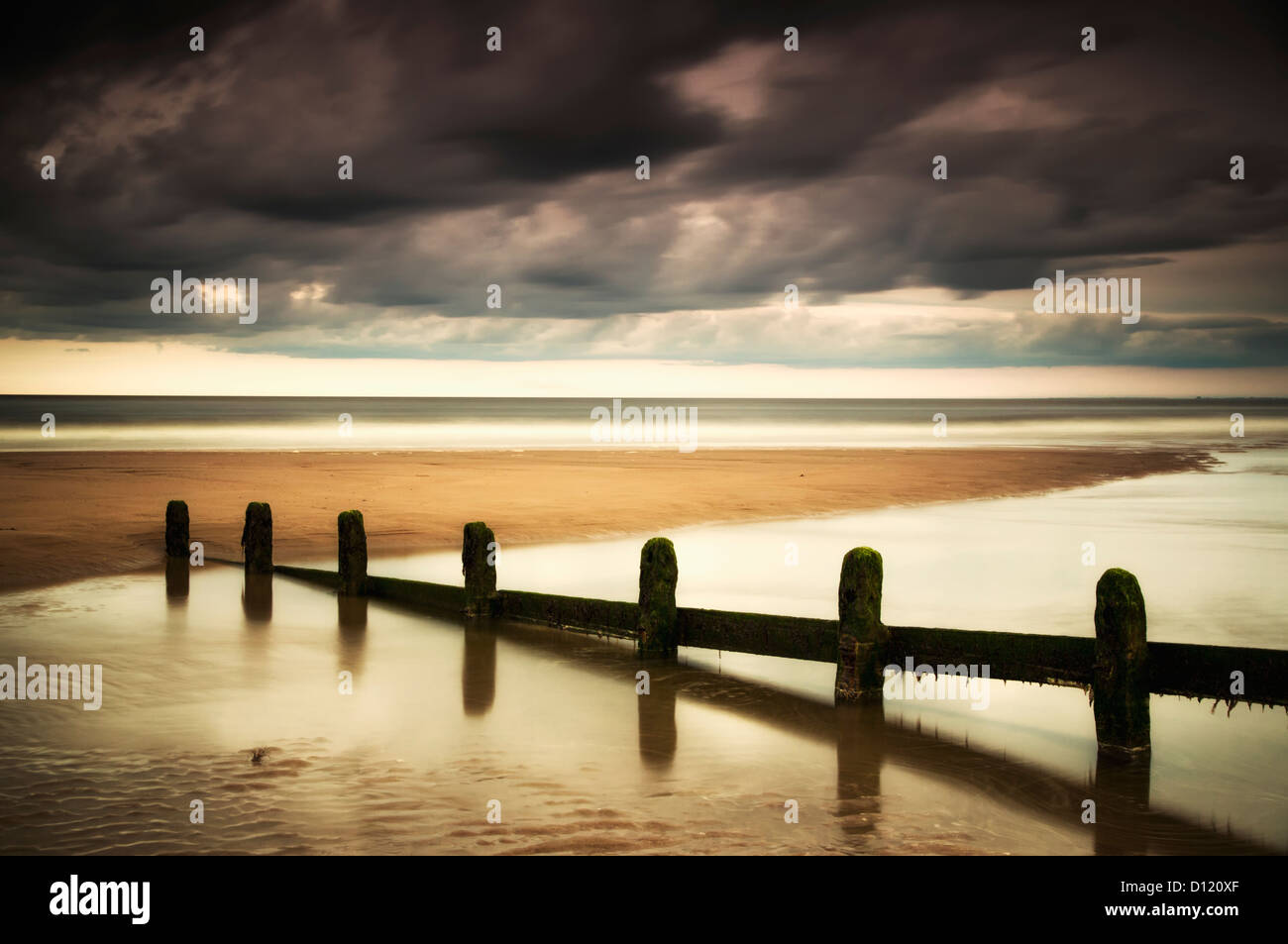 A Fence Submerged In The Water At The Coast With Storm Clouds Overhead ...