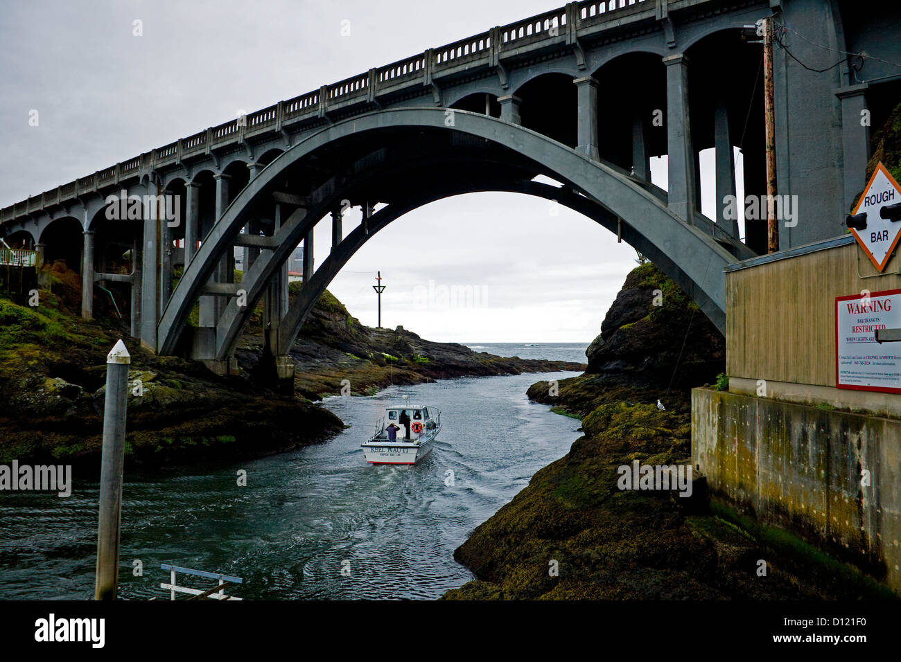 OR00267-00...OREGON - Boat motoring out the narrow channel of Depoe Bay ...