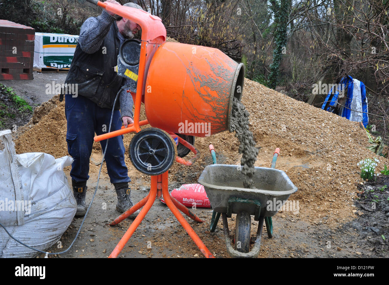 A labourer working the cement mixer on a building project UK Stock ...