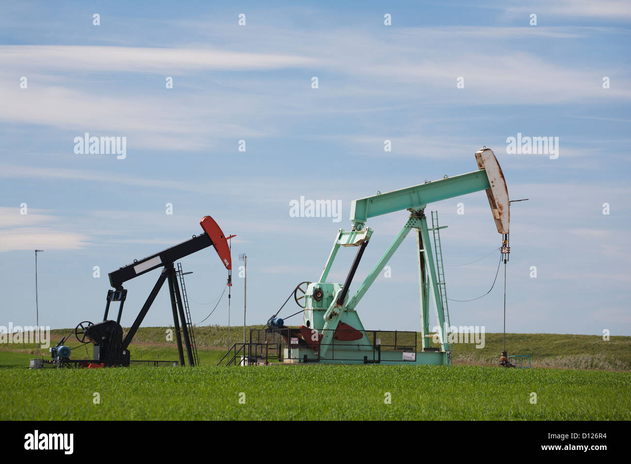 Two Pump Jacks In A Field With Clouds And Blue Sky East Of Airdrie ...