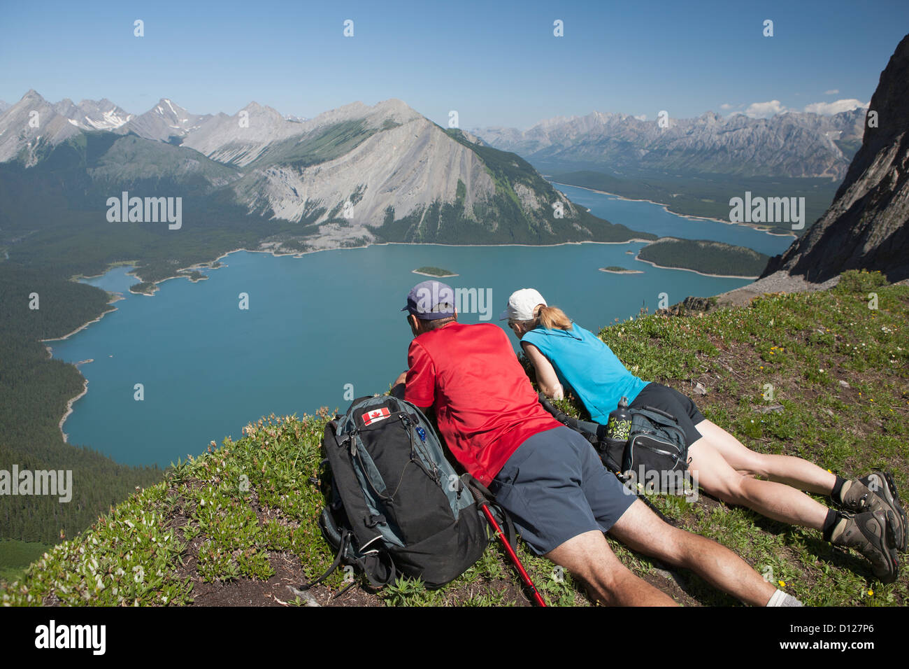 Male and female hiker laying down on a mountain ridge overlooking an ...