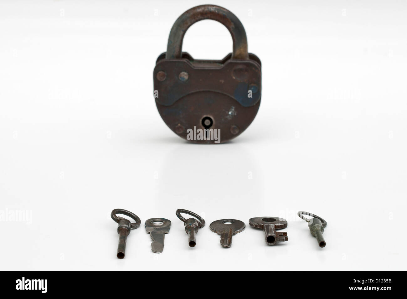 Old rusty padlock and set of six keys closeup against white background ...