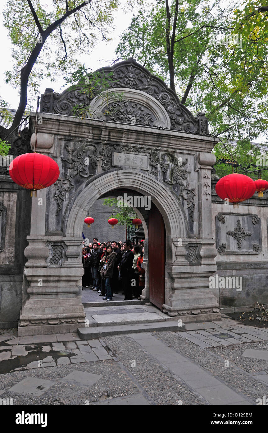 A Group Of People Stand On The Other Side Of An Ornate Stone Arch With ...