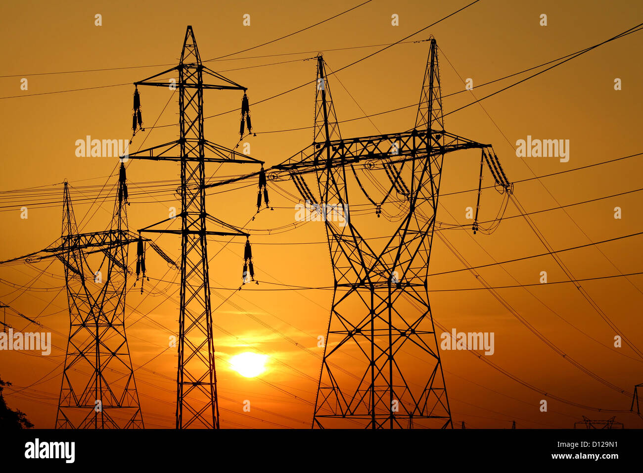 group of high voltage pole against sun Stock Photo - Alamy