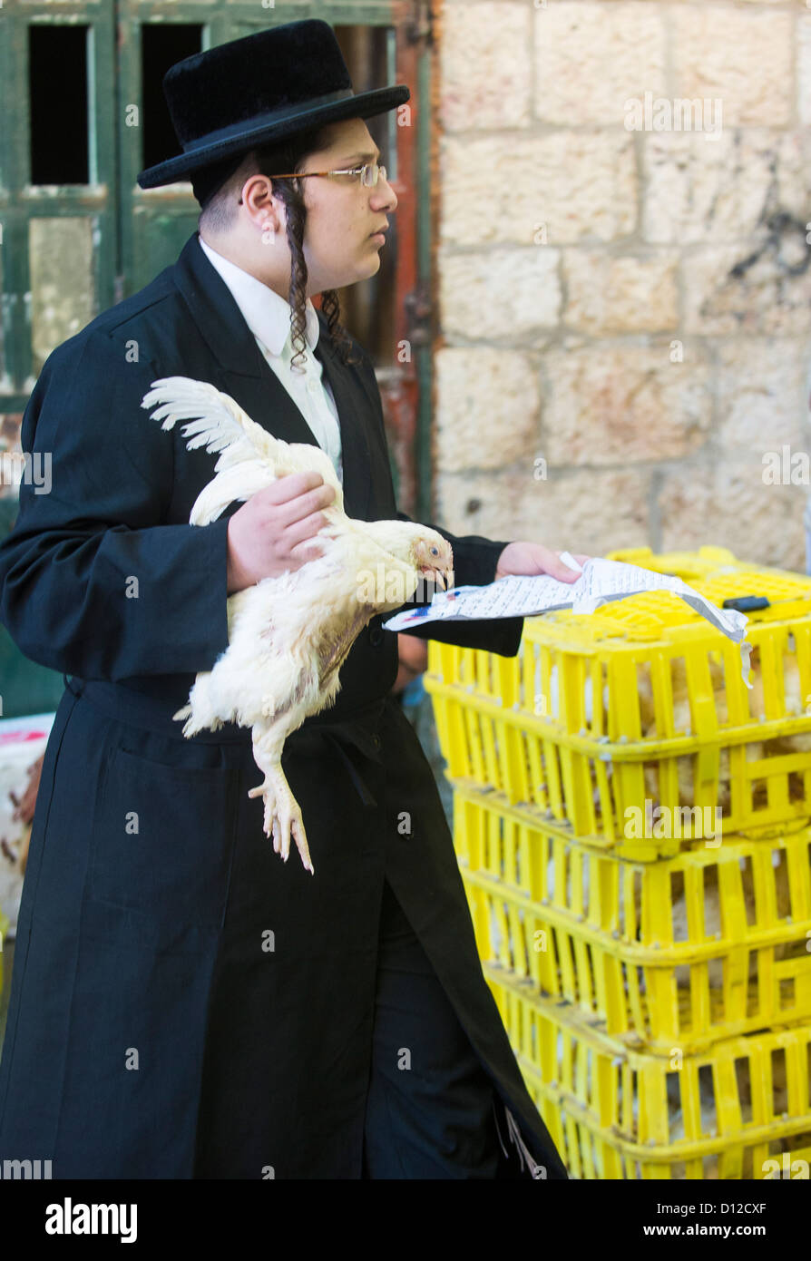 An ultra Orthodox Jewish man prays with a chicken during the Kaparot ...