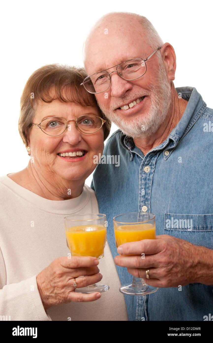 Happy Senior Couple With Glasses Of Orange Juice Isolated On A White