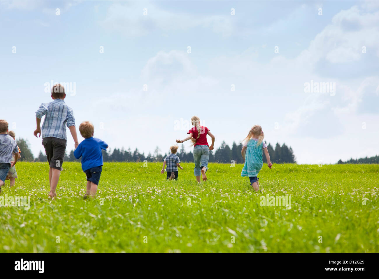 Germany, Bavaria, Group of children running through meadow Stock Photo ...
