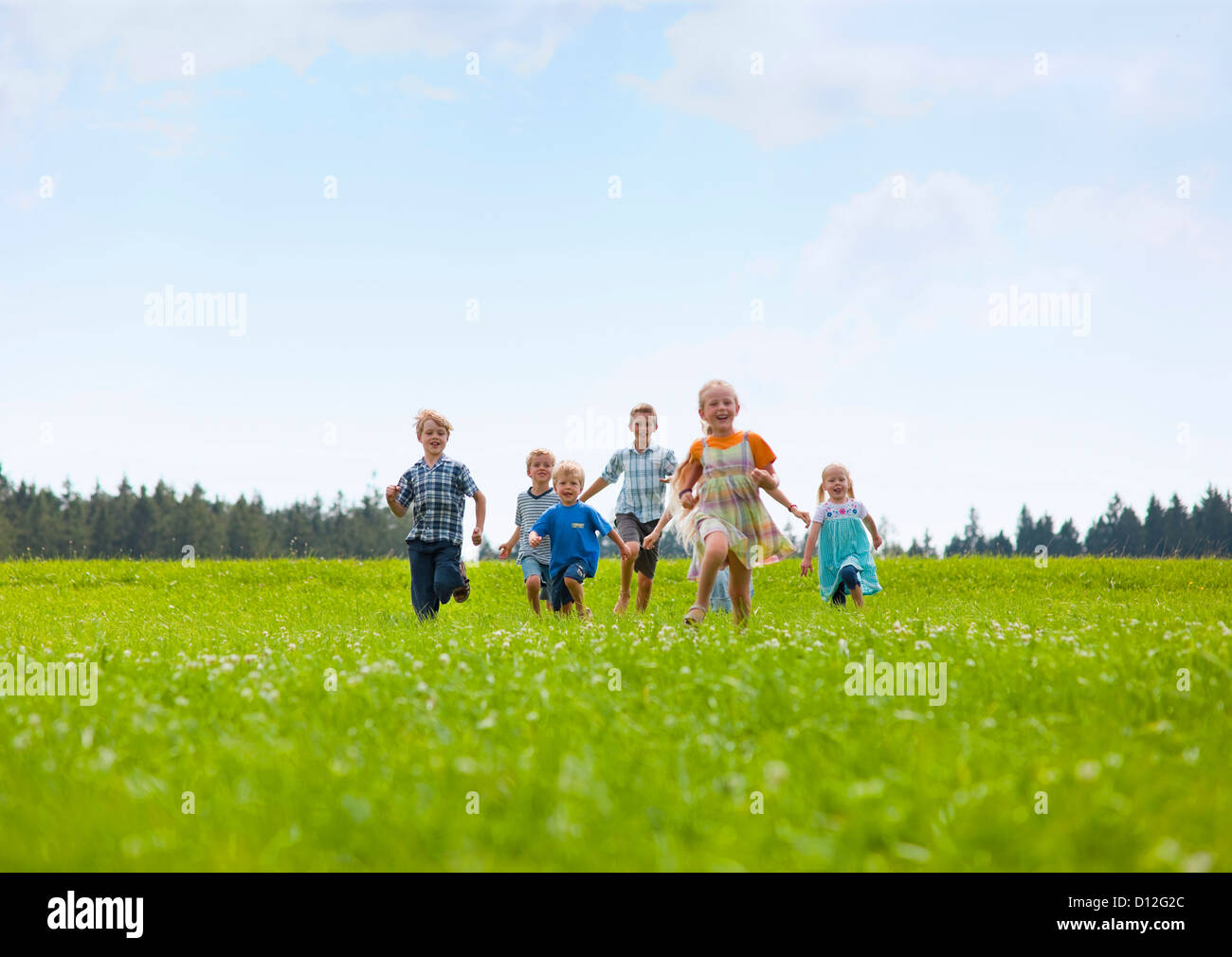 Germany, Bavaria, Group of children running through meadow Stock Photo ...