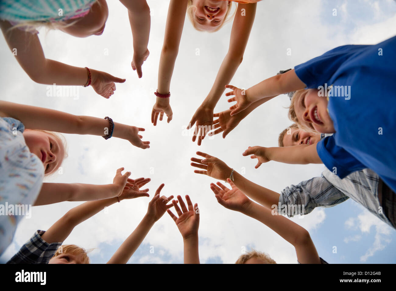 Germany, Bavaria, Group of children raising hands in air Stock Photo ...