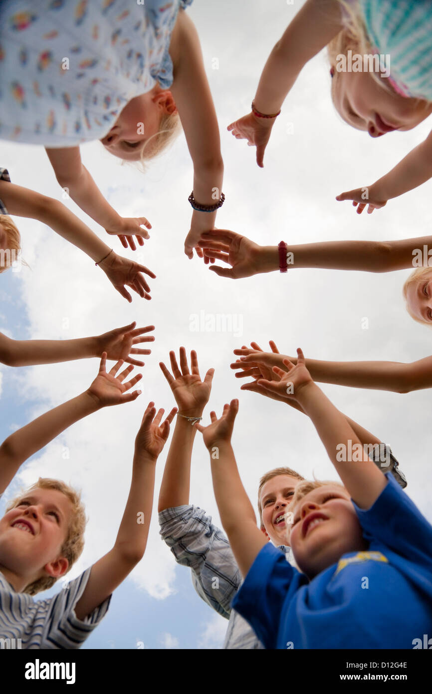 Germany, Bavaria, Group of children raising hands in air Stock Photo ...