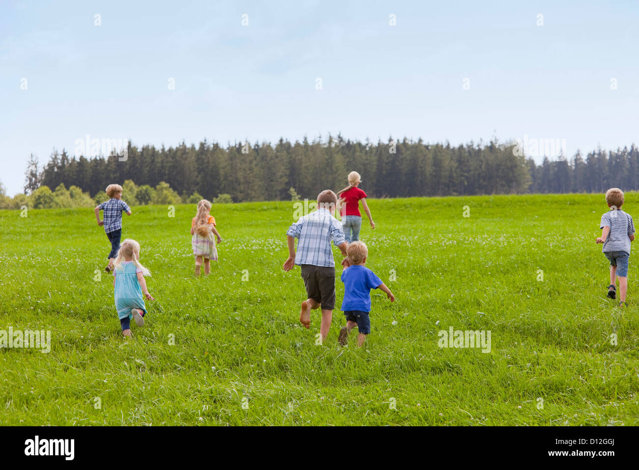 Germany, Bavaria, Group of children running through meadow Stock Photo ...