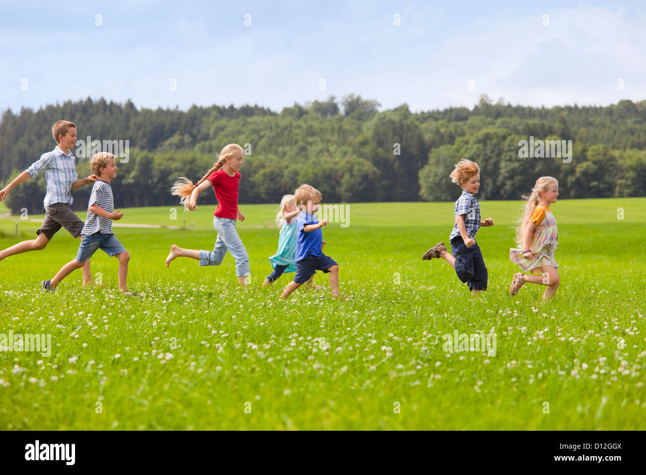 Germany, Bavaria, Group of children running through meadow Stock Photo ...