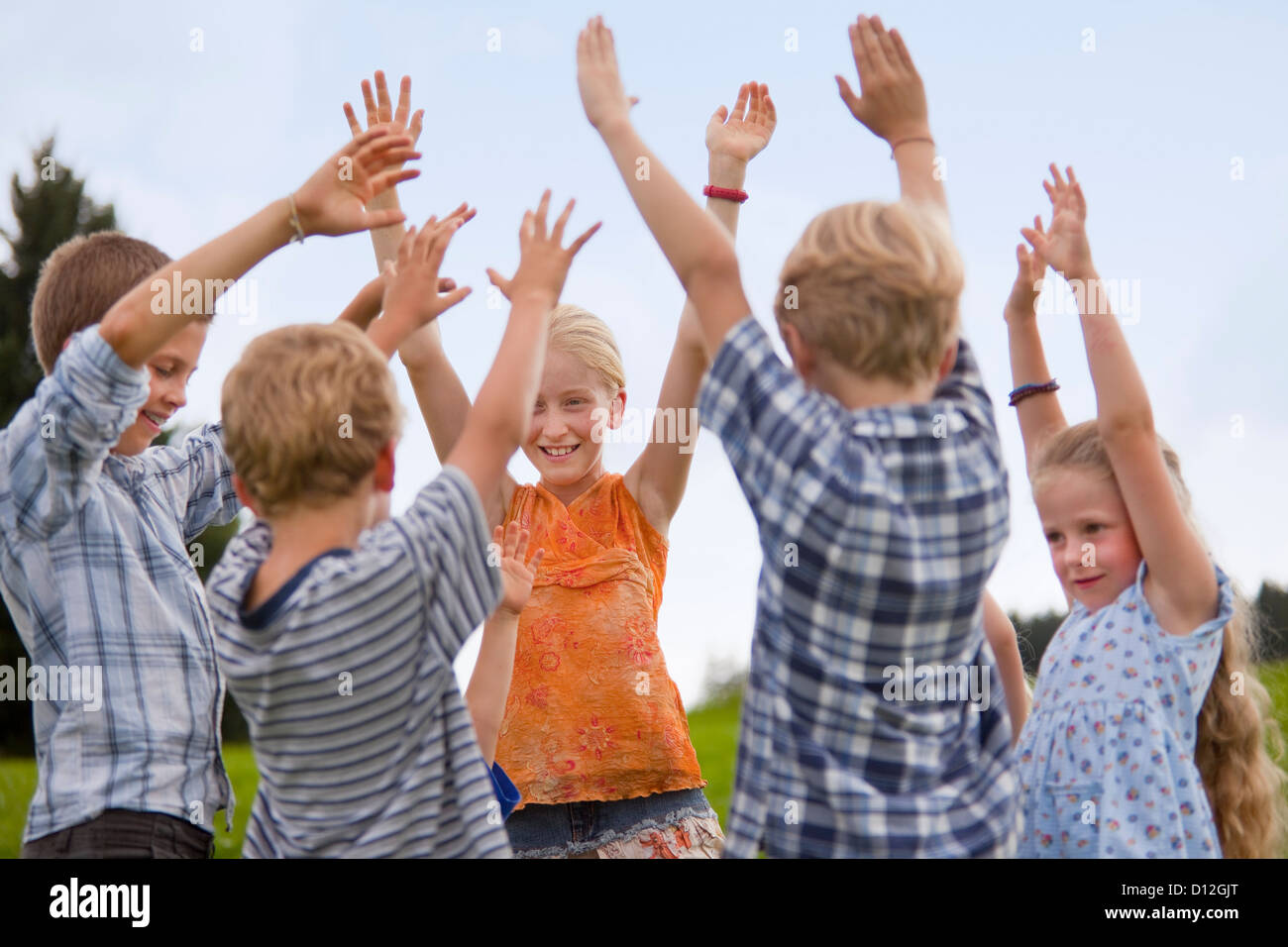 Germany, Bavaria, Group of children raising hands in air Stock Photo ...
