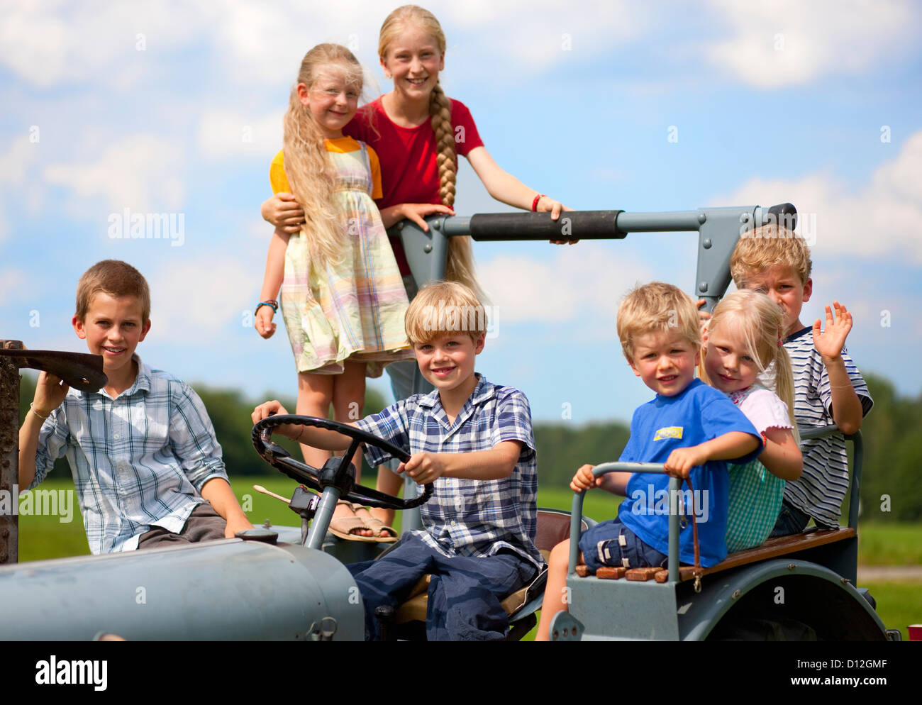 Germany, Bavaria, Group of children sitting in old tractor Stock Photo ...