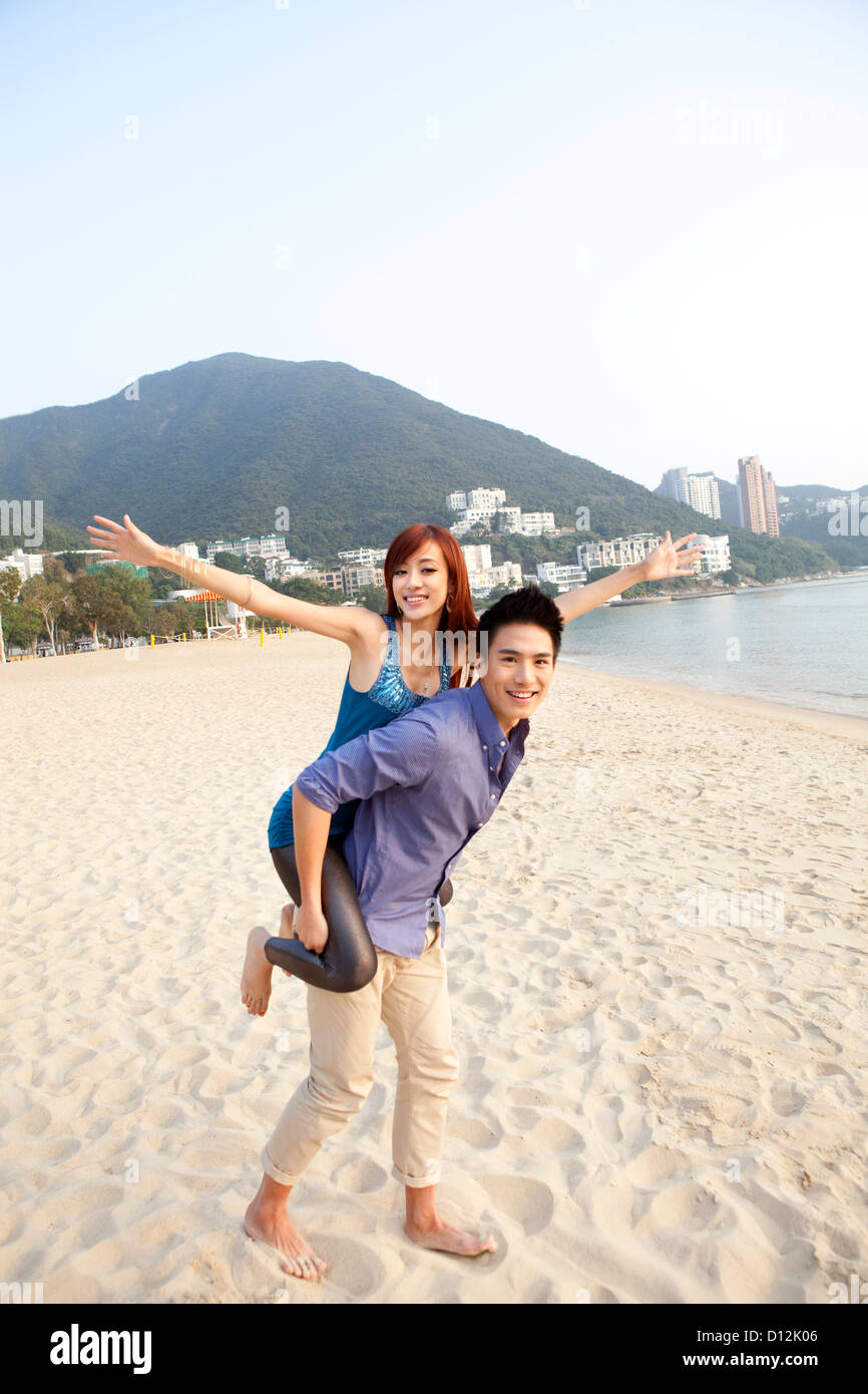 Sweet young couple playing piggyback on the beach of Repulse Bay, Hong ...