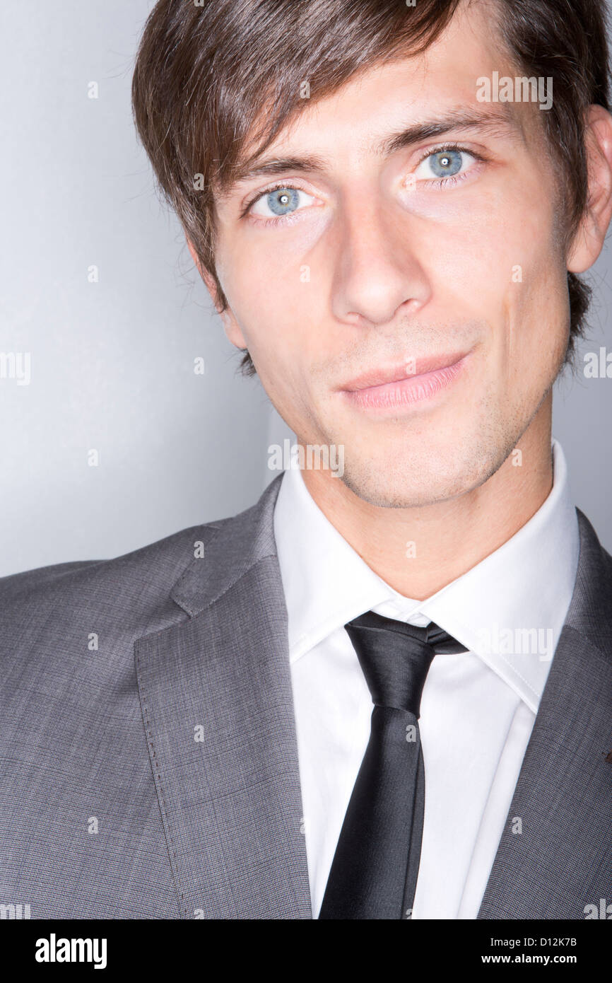 Young man in grey suit, smiling, portrait Stock Photo - Alamy
