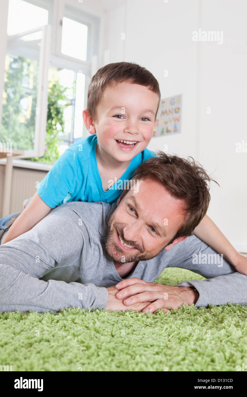 Germany, Berlin, Father and son having fun at home, smiling Stock Photo ...