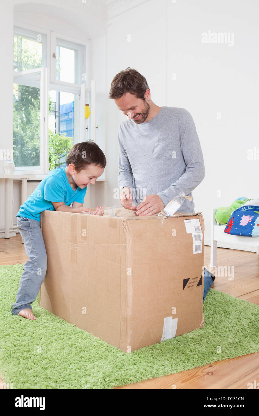 Germany, Berlin, Father and son opening parcel box Stock Photo - Alamy