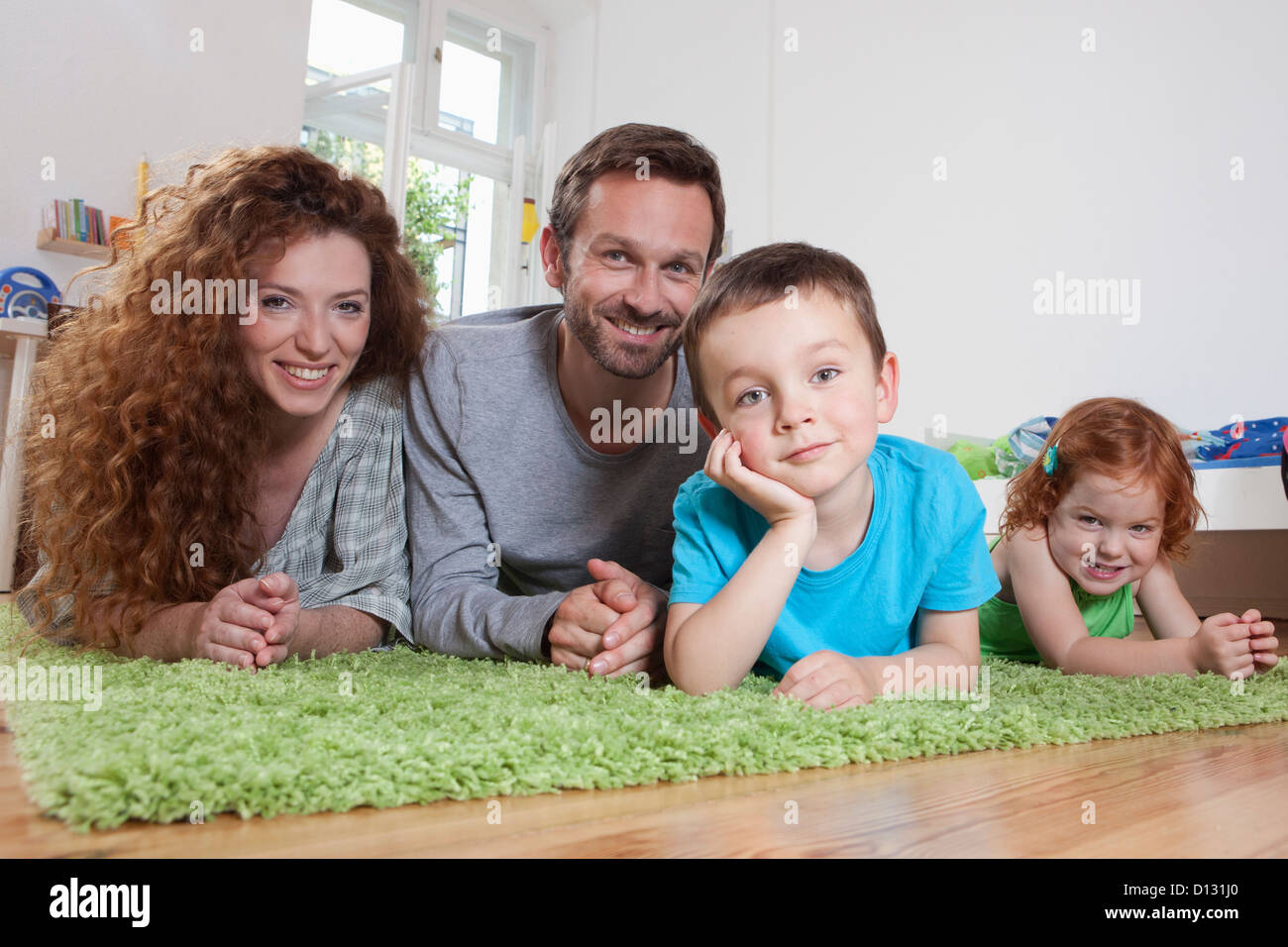 Germany, Berlin, Family lying on floor, smiling, portrait Stock Photo ...