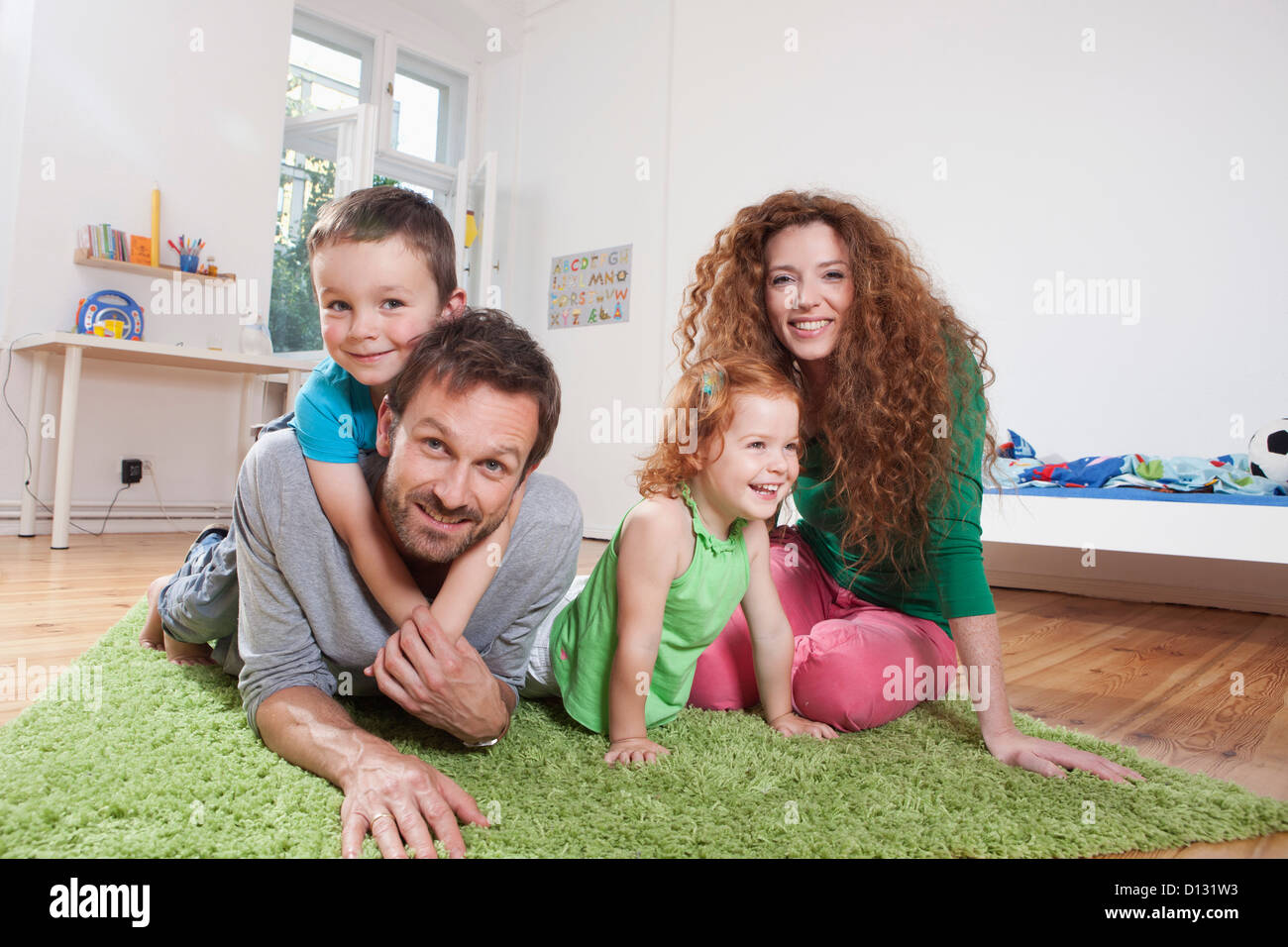 Germany, Berlin, Family sitting on floor, smiling, portrait Stock Photo ...