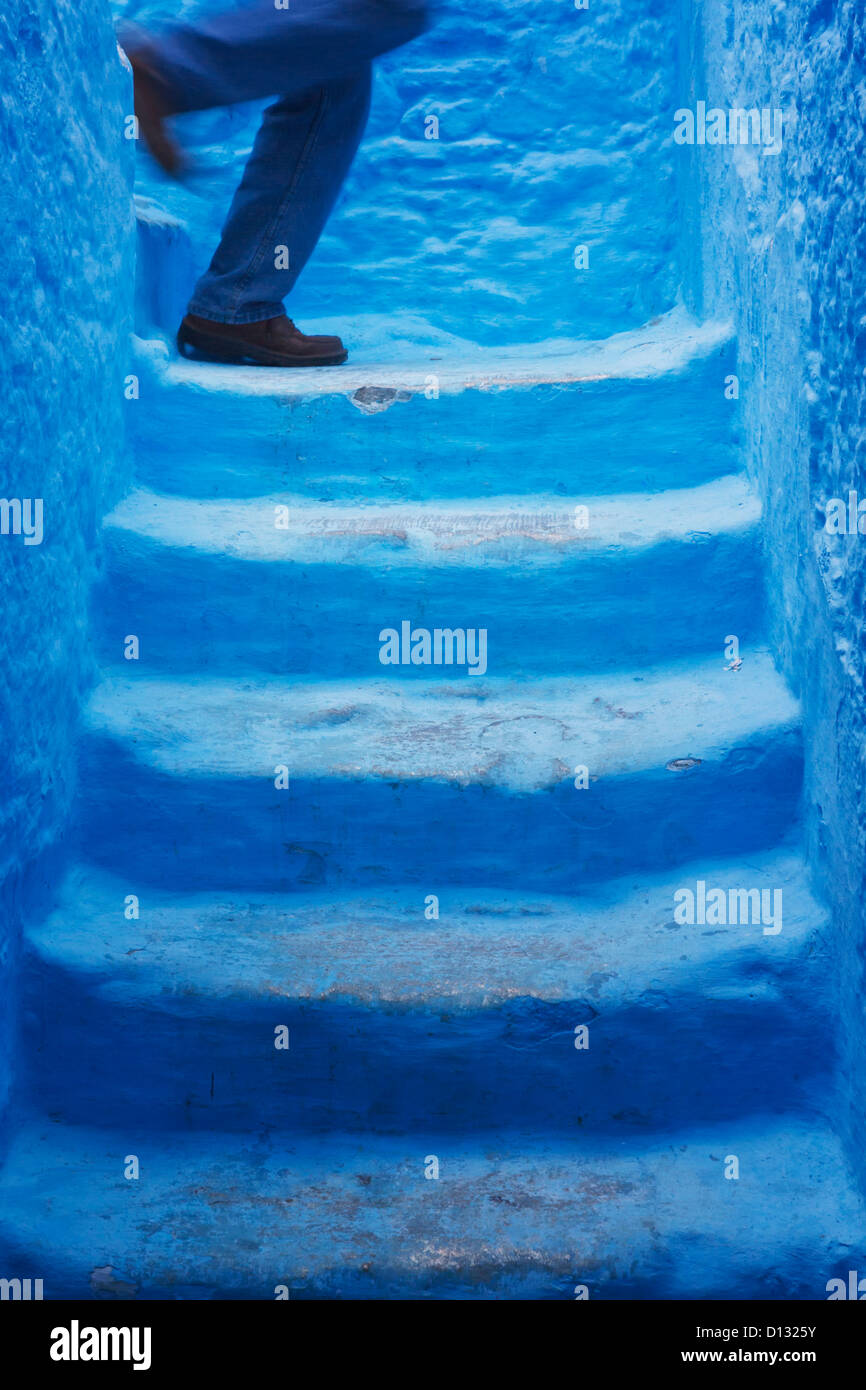 A Man Walking On Blue Steps In The Medina; Chefchaouen Morocco Stock ...