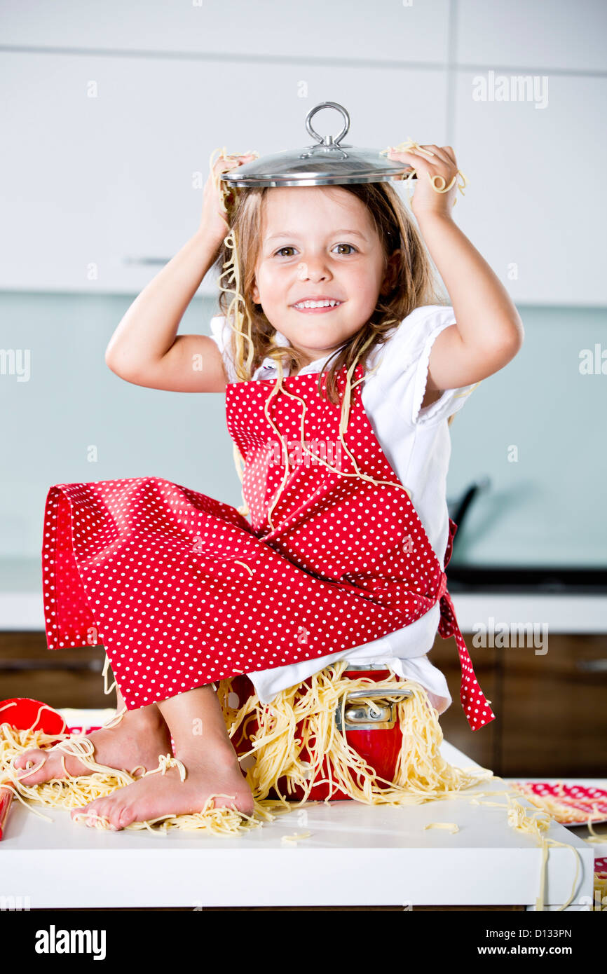Germany, Girl playing with spaghetti on kitchen worktop Stock Photo - Alamy