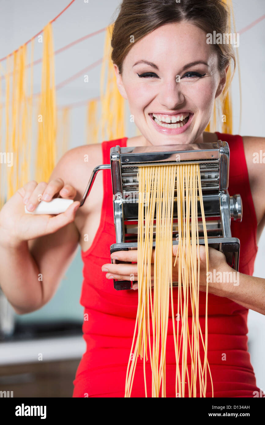Germany, Young woman making pasta with machine Stock Photo - Alamy