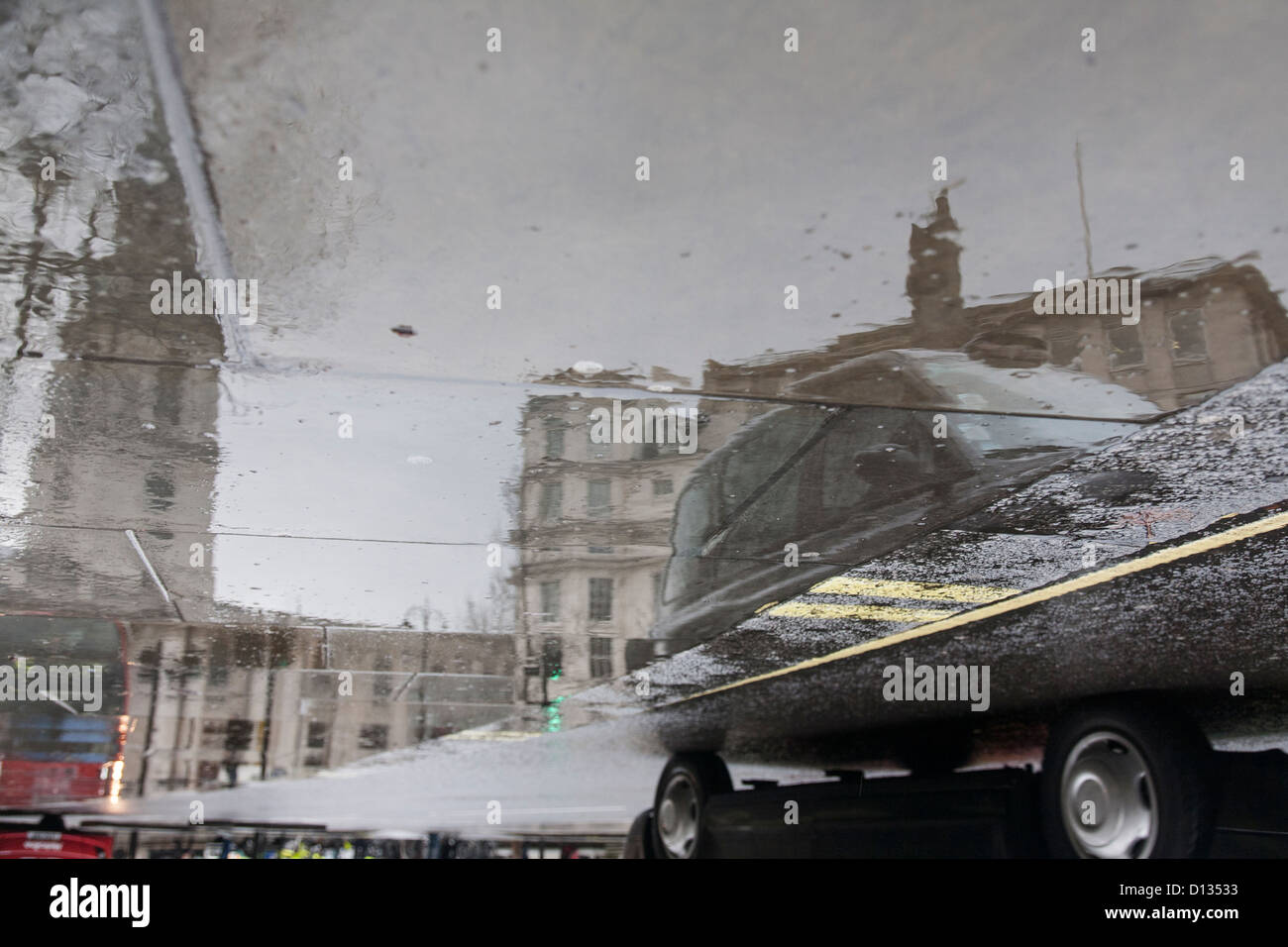 Picture of a puddle on the pavement reflecting a London Black Cab and a ...