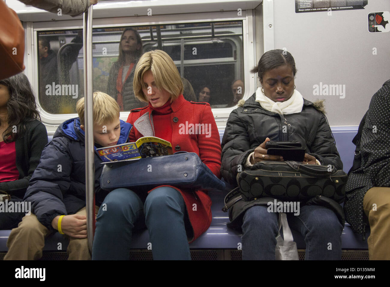 Mother and son involve in a common interest while riding the subway in ...