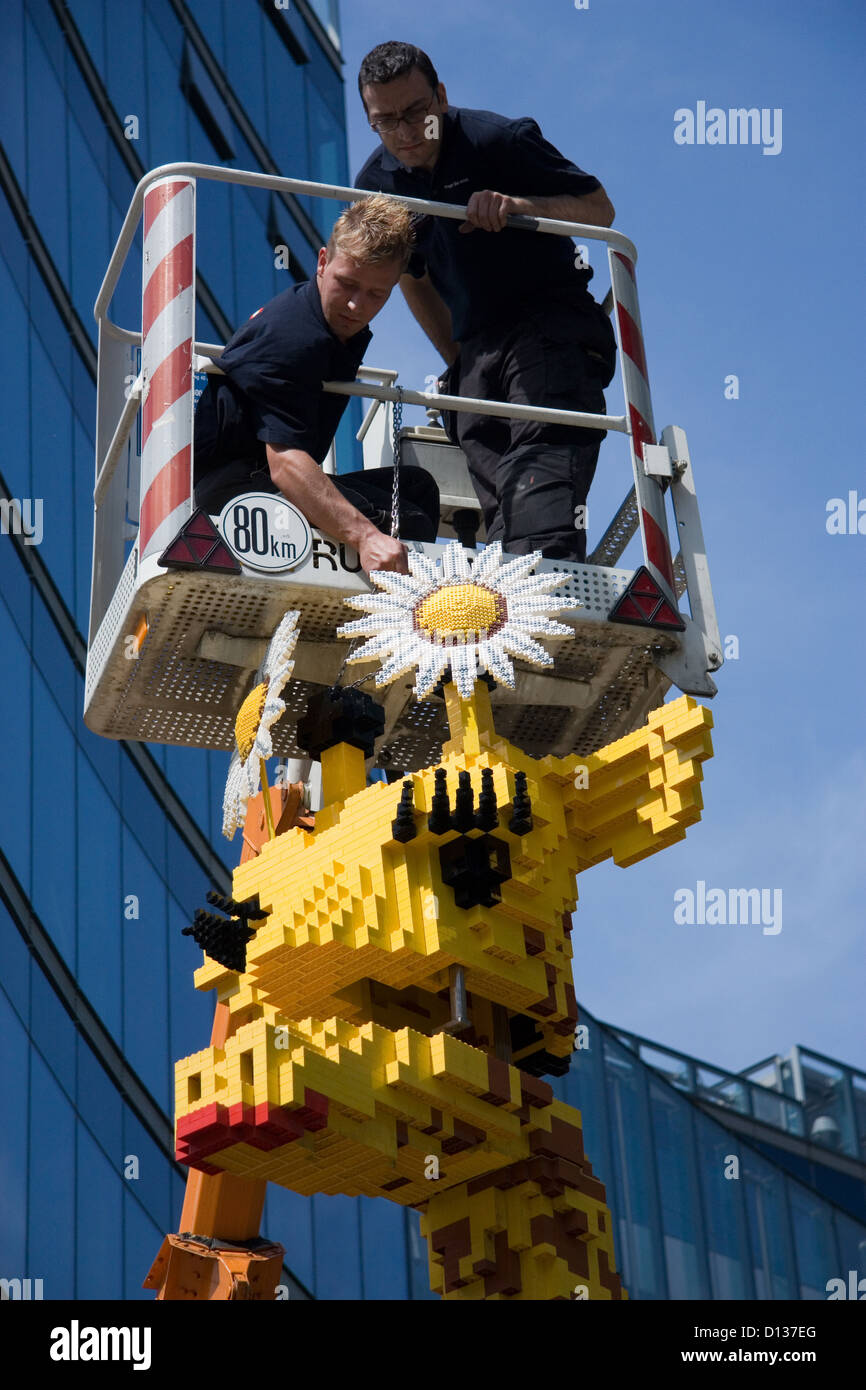 Berlin, Germany, artisans give the Lego giraffe at Sony Center, a new ...