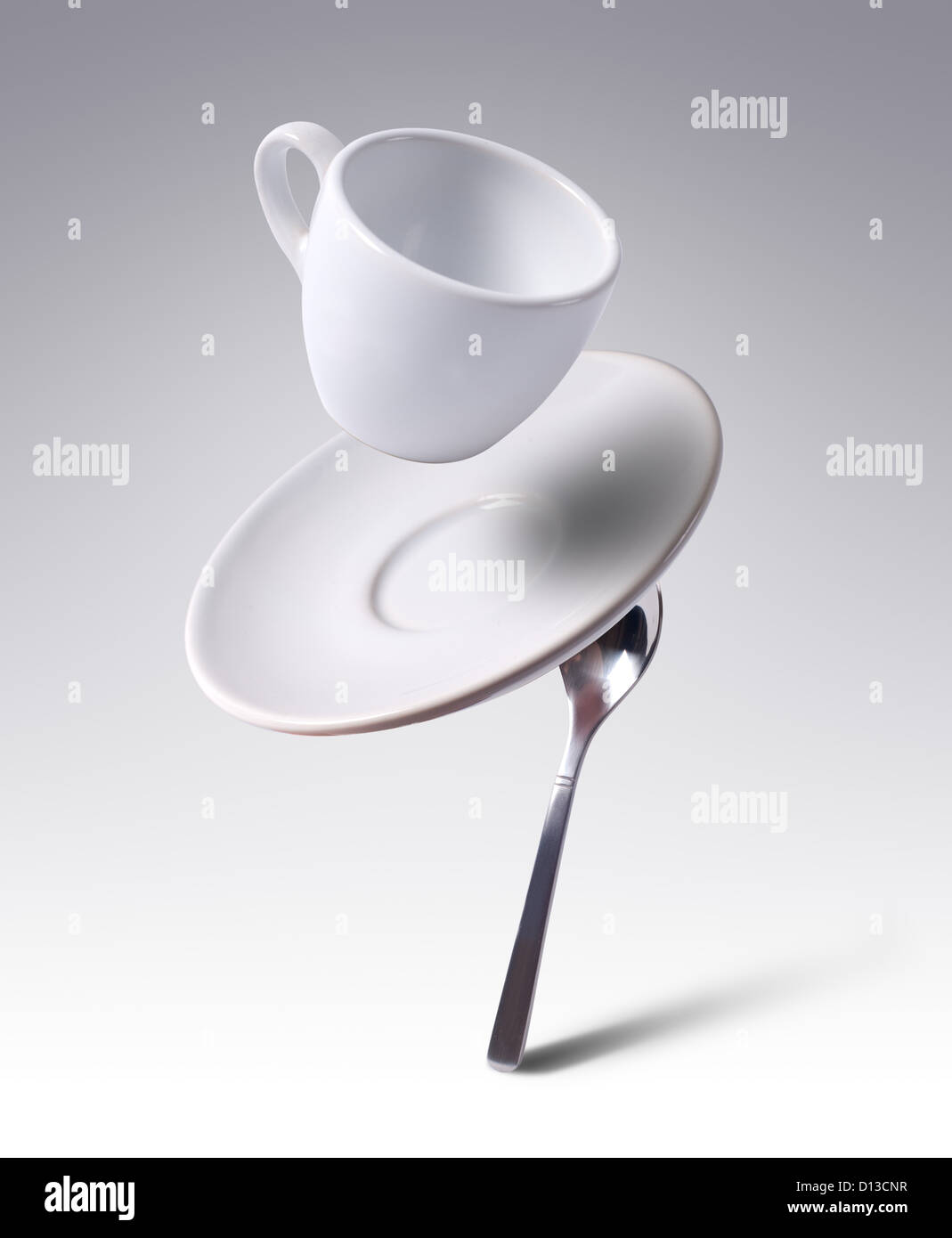 falling coffee cup with spoon and saucer Stock Photo - Alamy