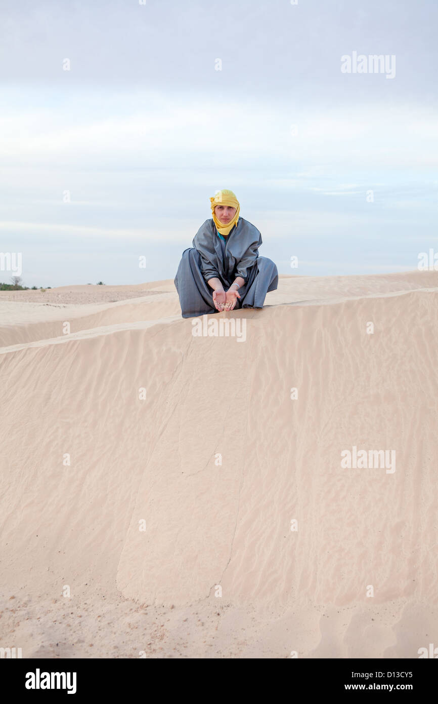 Caucasian male in protection eastern clothes pouring sand by hands on ...