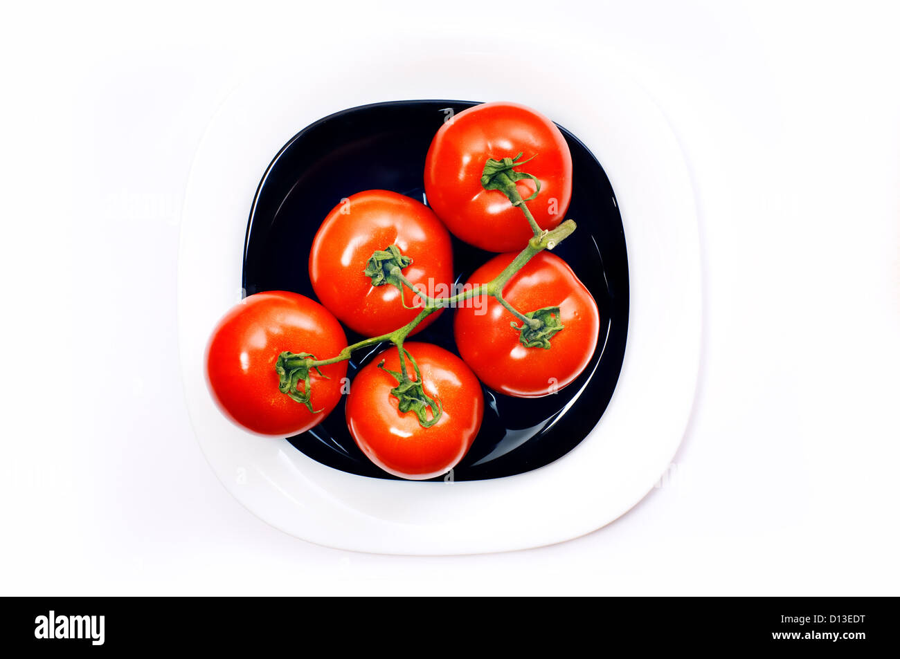 bunch of five tomato on black and white plates Stock Photo - Alamy