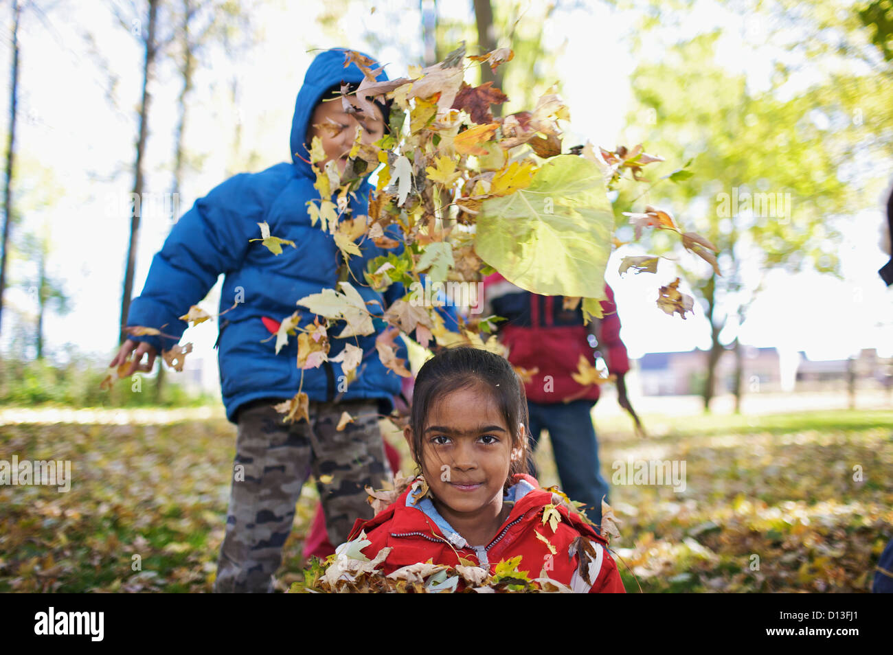 Multi-Ethnic New Canadian Children Playing In Autumn Leaves Outside Esl ...