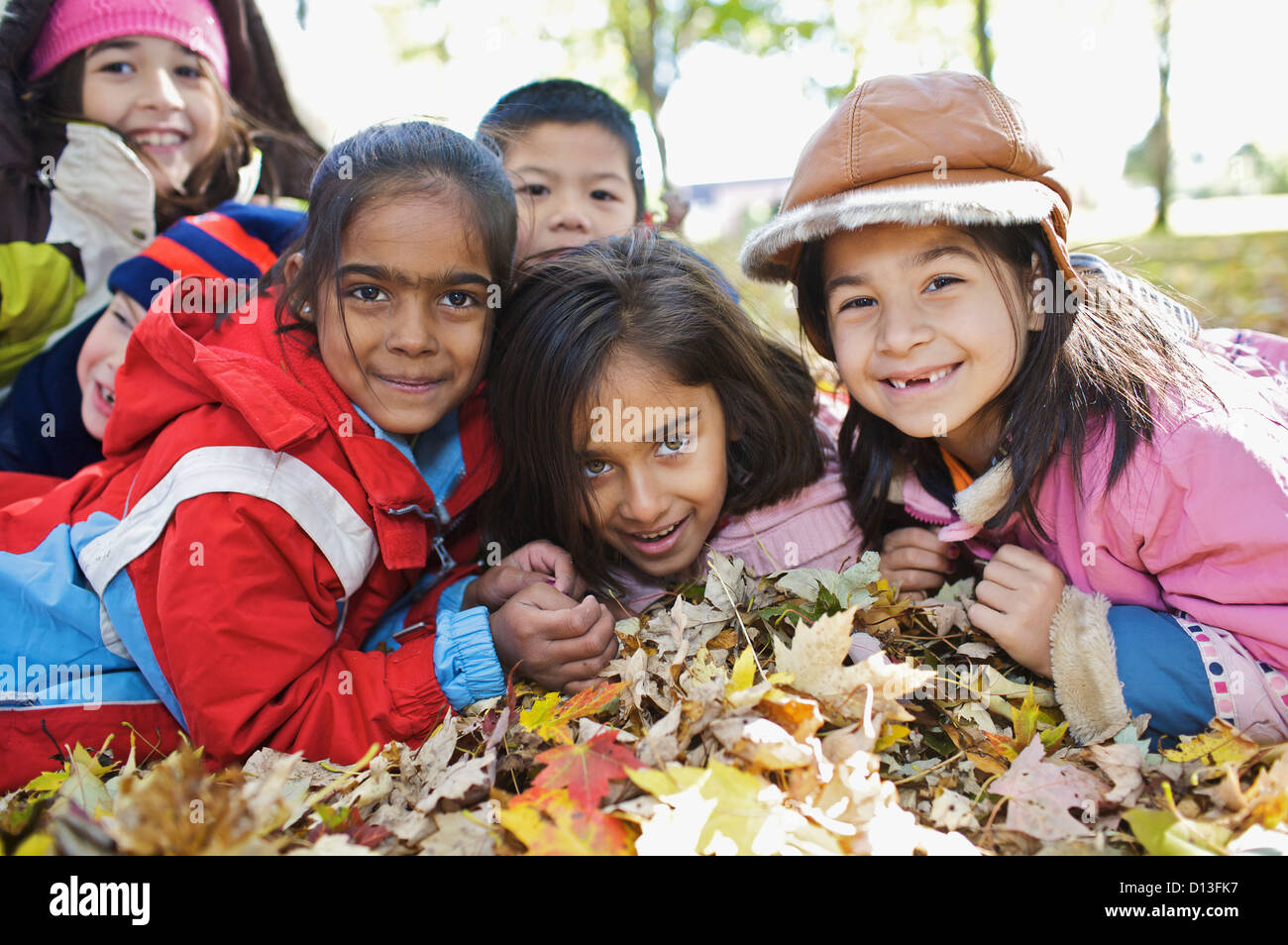 Multi-Ethnic New Canadian Children Playing In Autumn Leaves Outside Esl ...