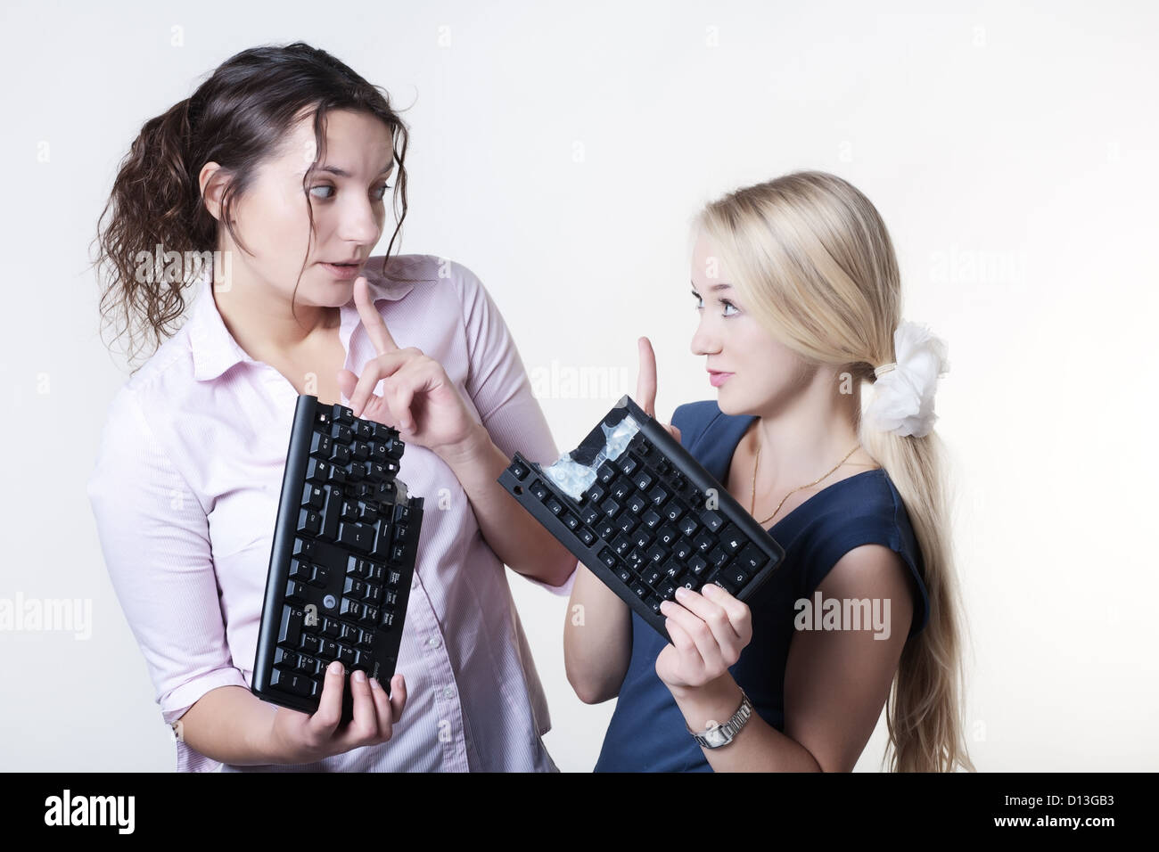 two woman holding a broken keyboard Stock Photo - Alamy