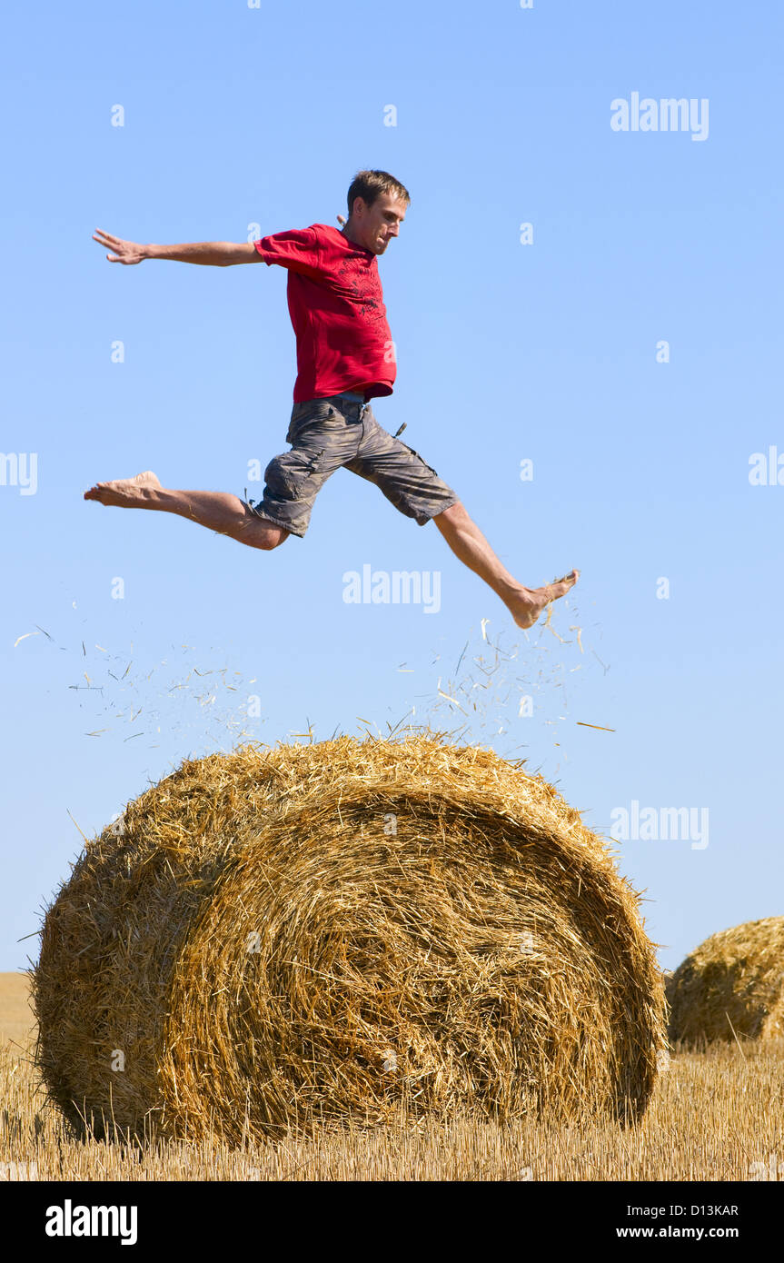 man jumping up on straw roll Stock Photo - Alamy
