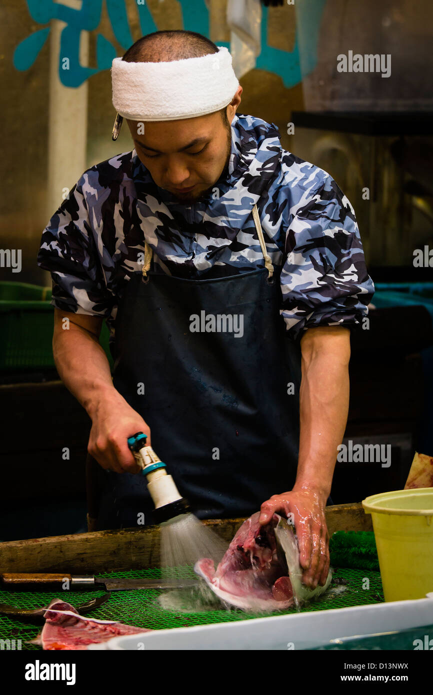 A fishmonger cleans a fish head in Tsukiji Fish Market, Tokyo Stock ...
