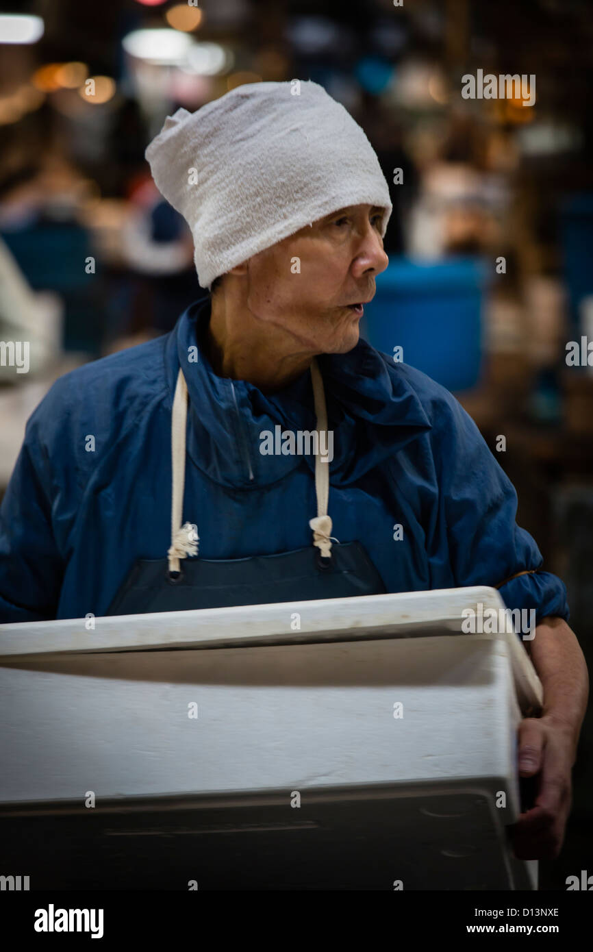 Man carrying a styrofoam box with ice where the fish are kept fresh ...