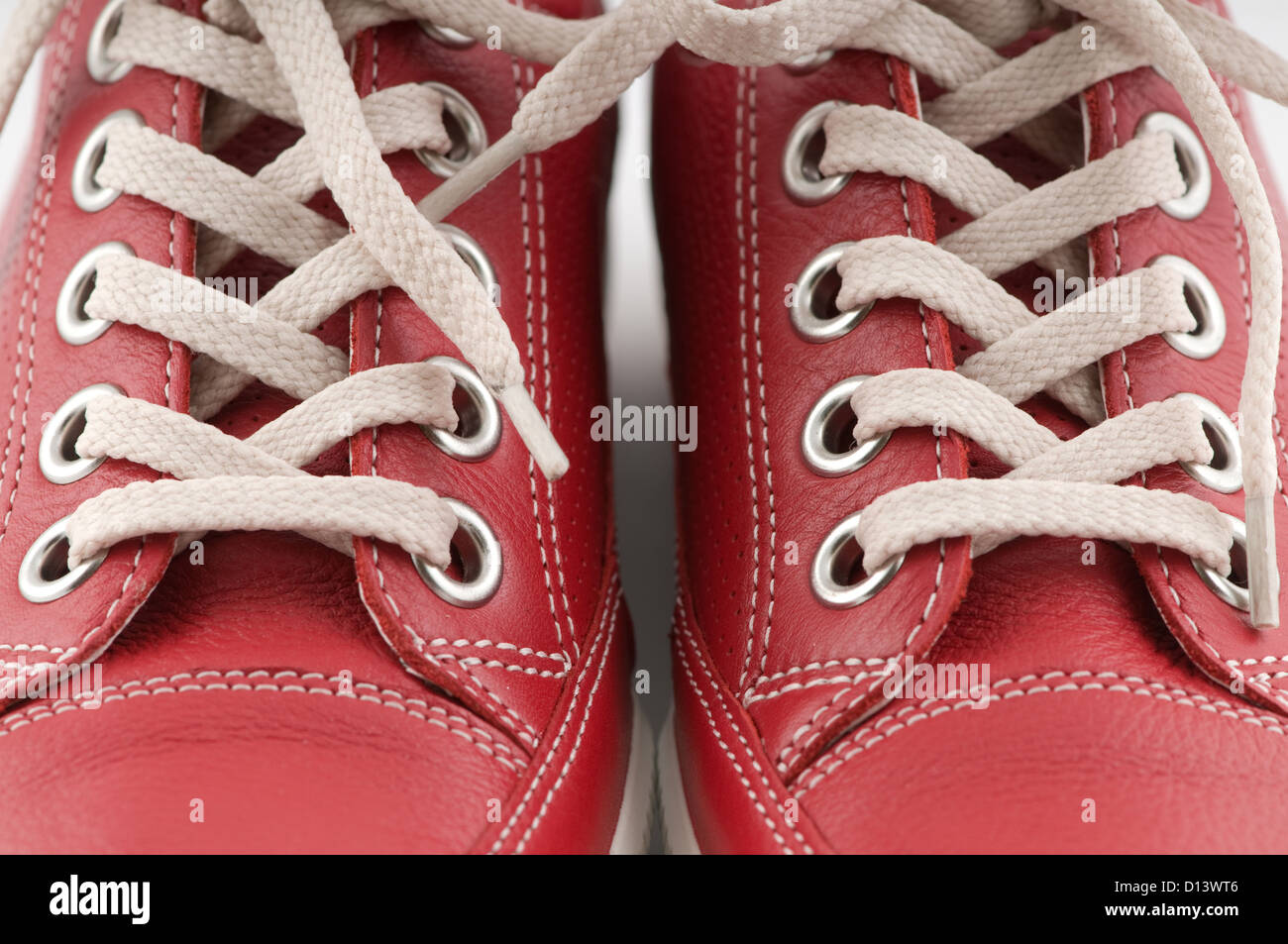 red leather sneakers on white Stock Photo - Alamy