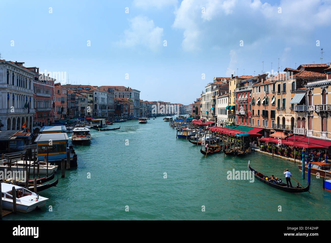A Gondolda and other boats move along the famous Grand Canal in the ...